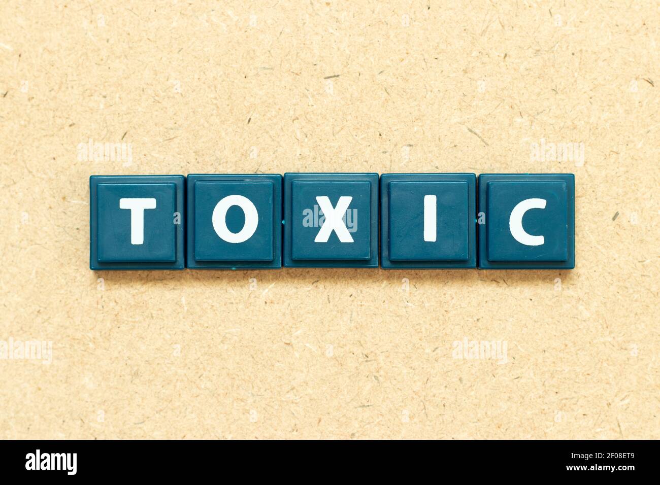 Tile alphabet letter in word toxic on wood background Stock Photo - Alamy