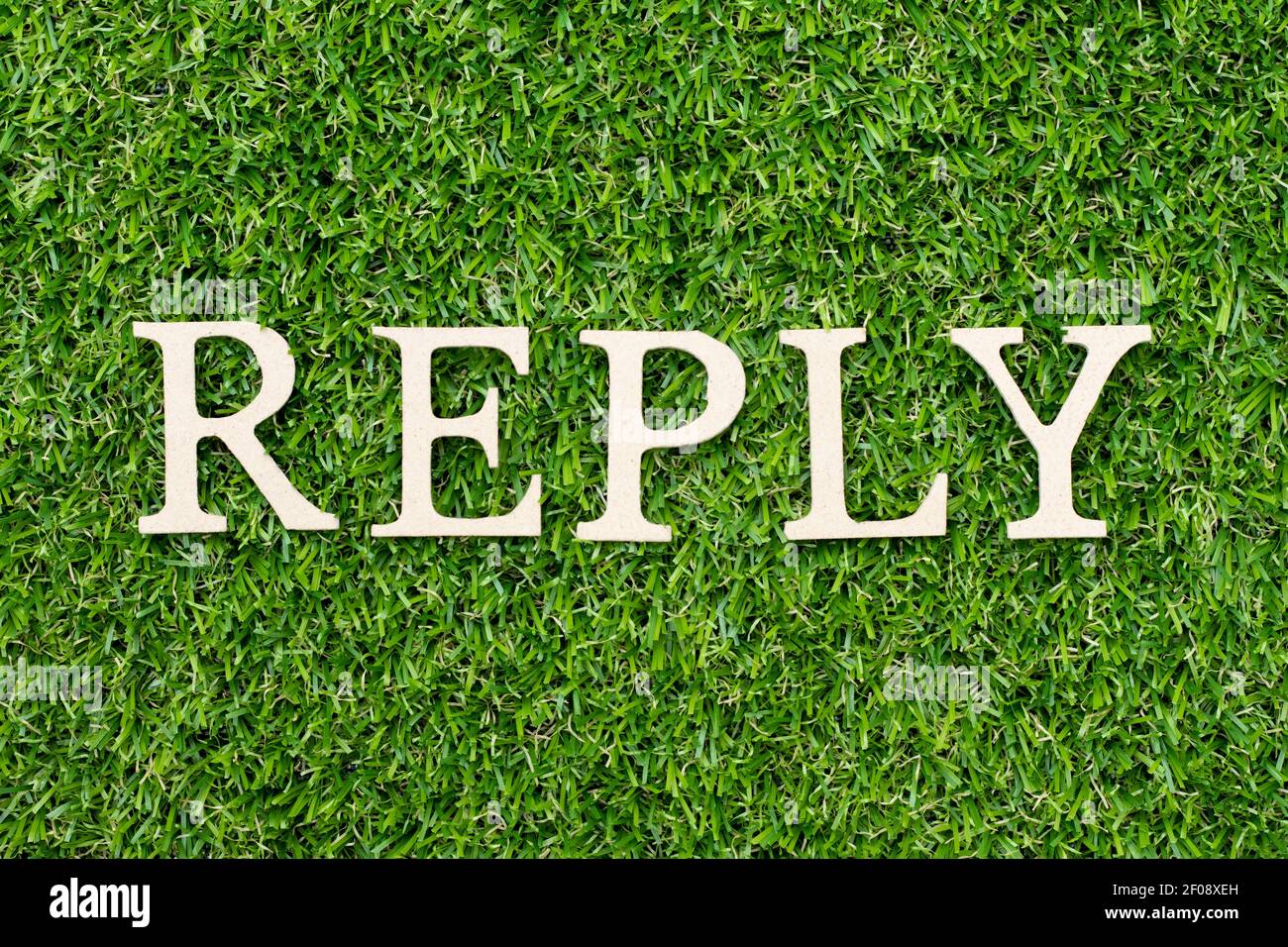 Wood alphabet letter in word reply on green grass background Stock ...