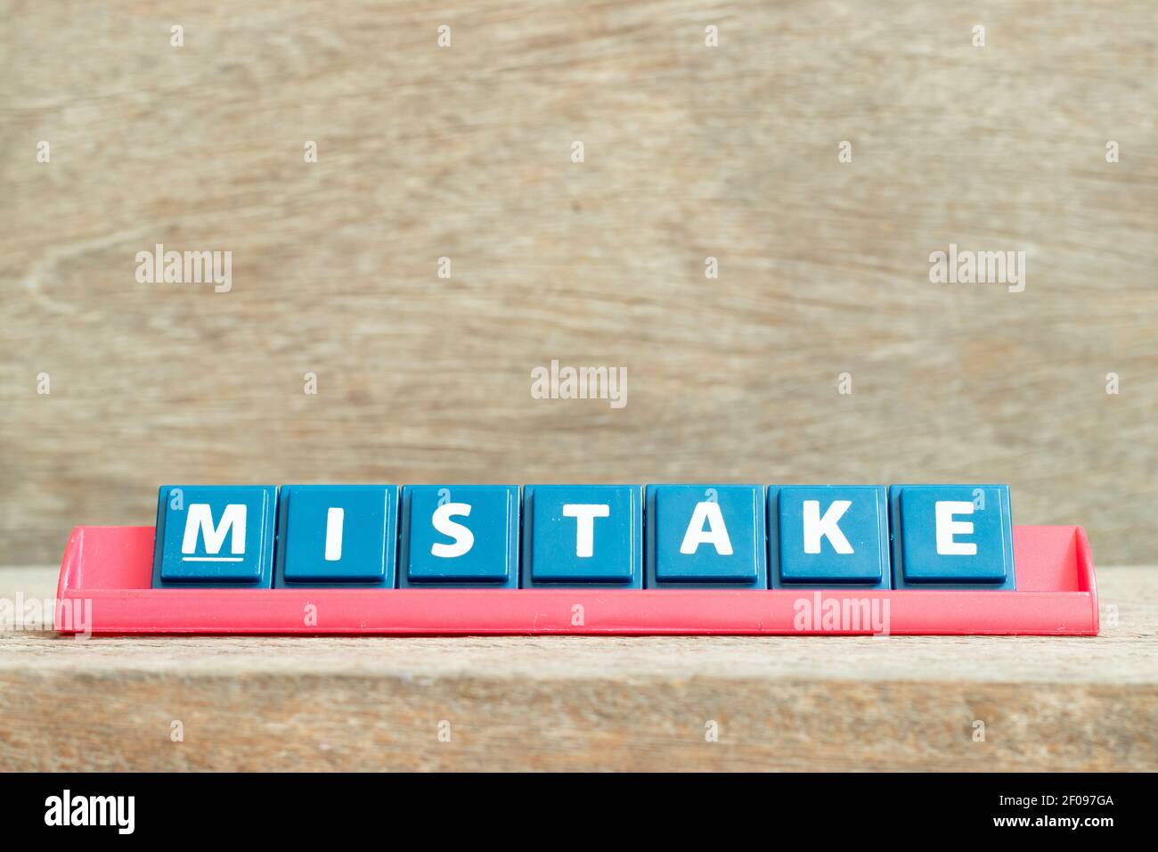 Tile alphabet letter with word mistake in red color rack on wood ...