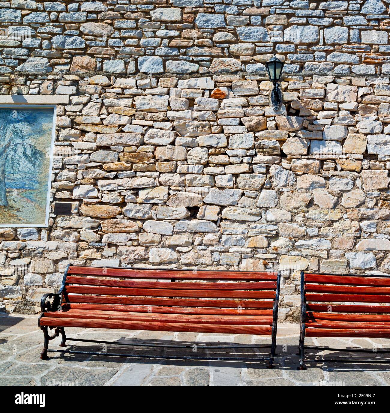In the greece island of paros old bench near a brick antique wall and ...