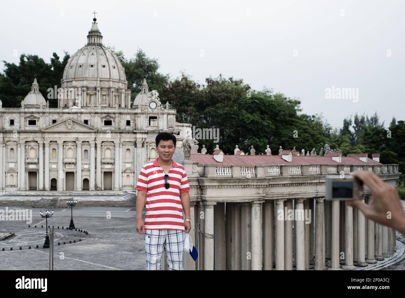 A Chinese man is being photographed in front of the Vatican replica ...