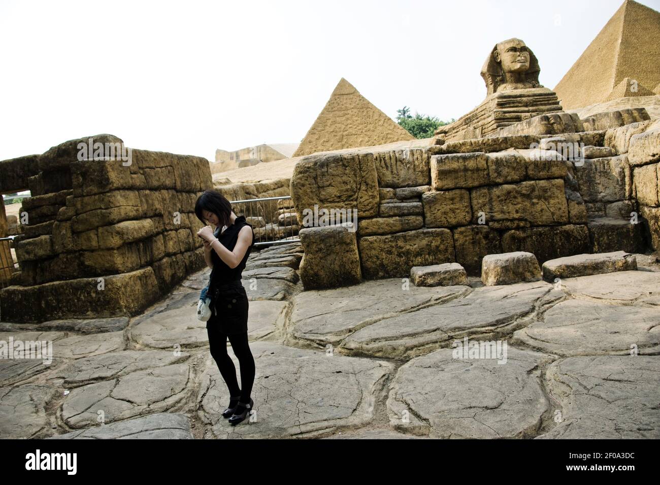 A young woman in front of the Egyptian pyramids and Sphynx replicas ...