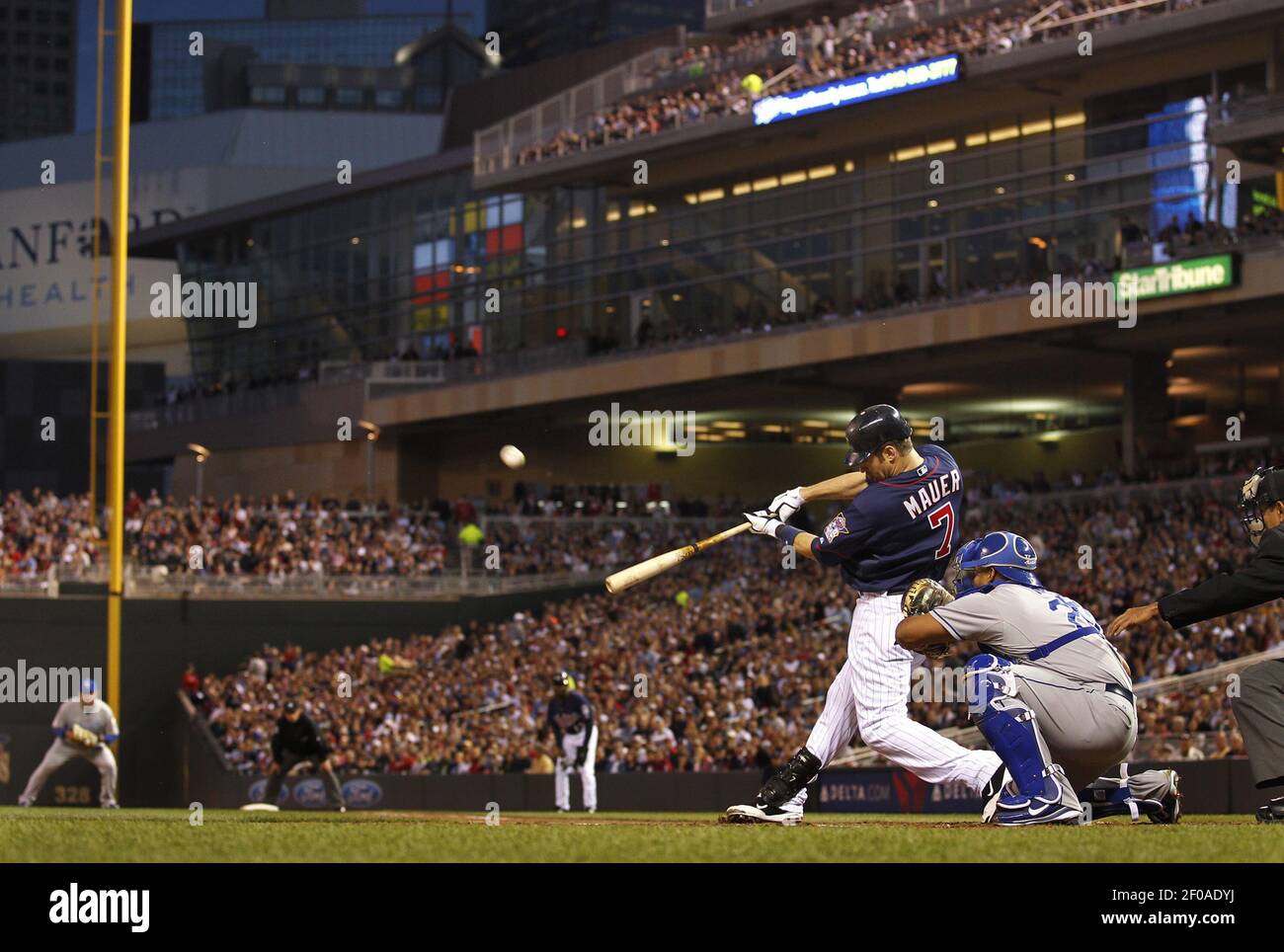 Joe Mauer of the Minnesota Twins hits a sacrifice fly ball in the third ...