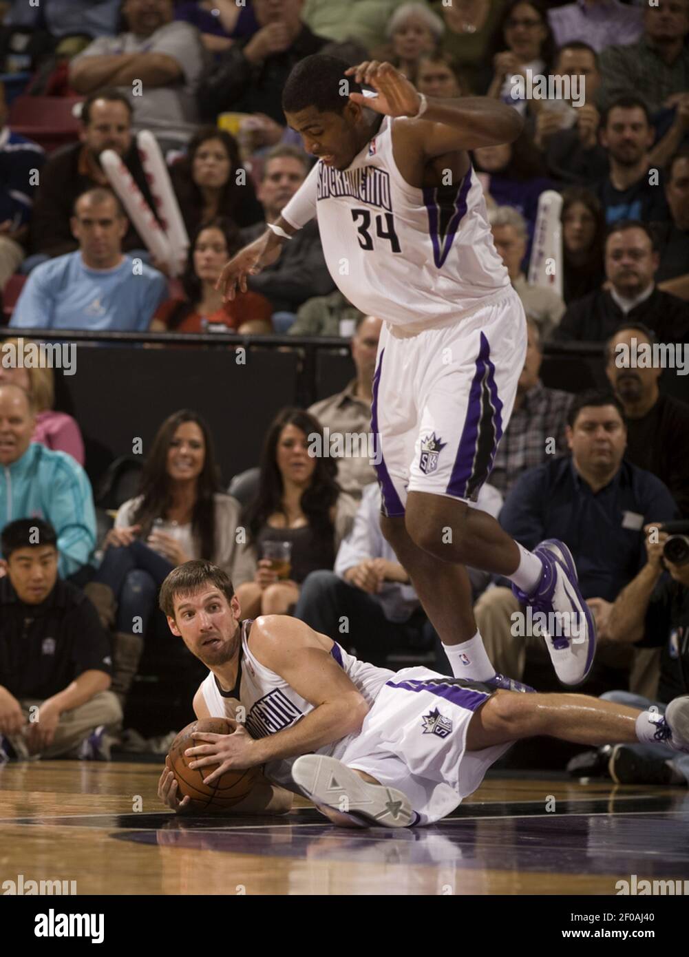 The Sacramento Kings' Jason Thompson leaps over teammate Beno Udrih ...
