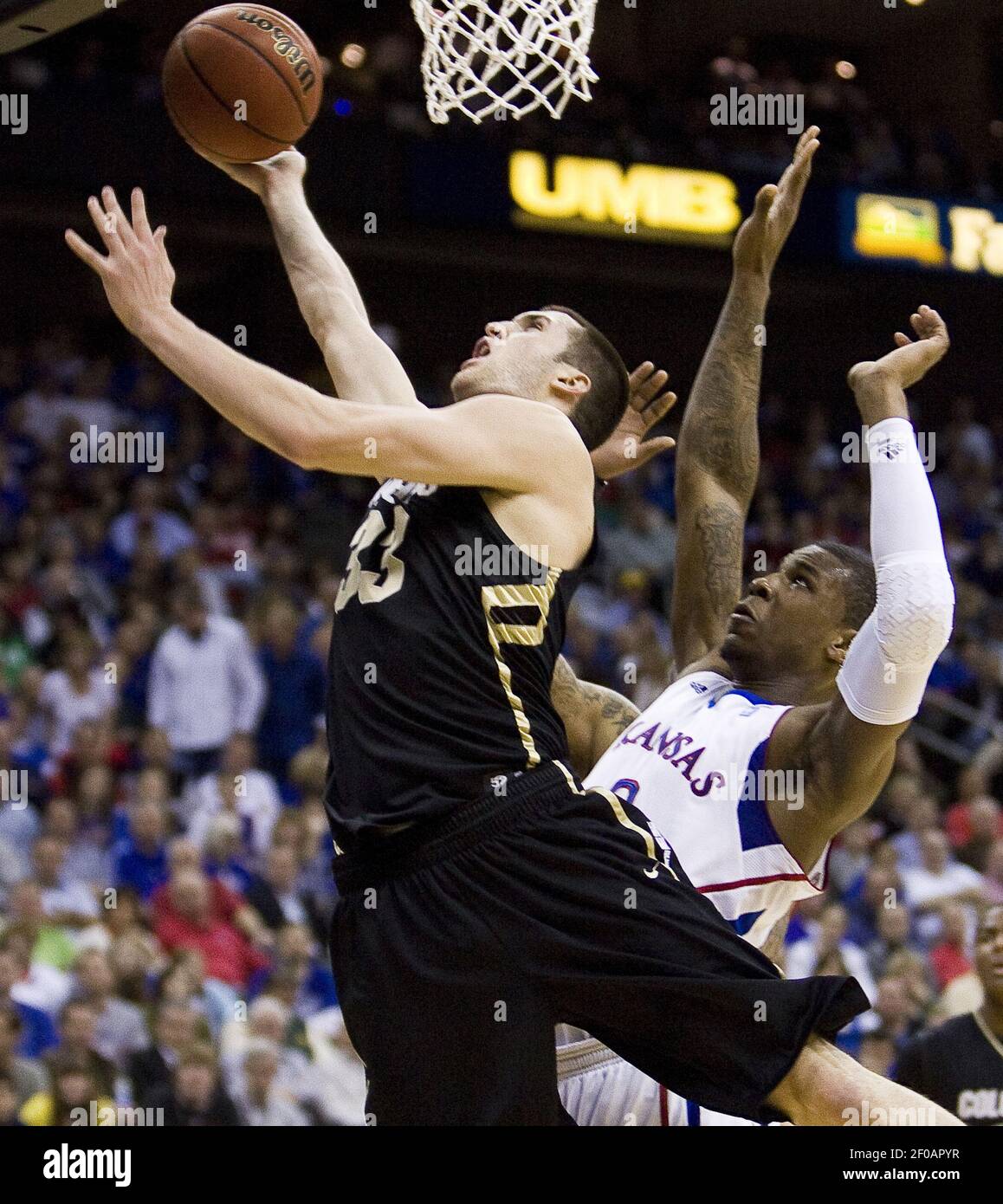 Colorado's Austin Dufault (33) slips by Kansas' Thomas Robinson for a ...