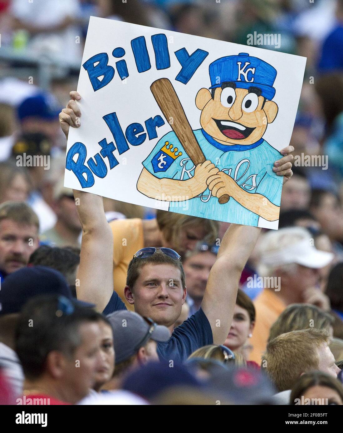 A fan displays his own poster that included his cartoon of Kansas City ...