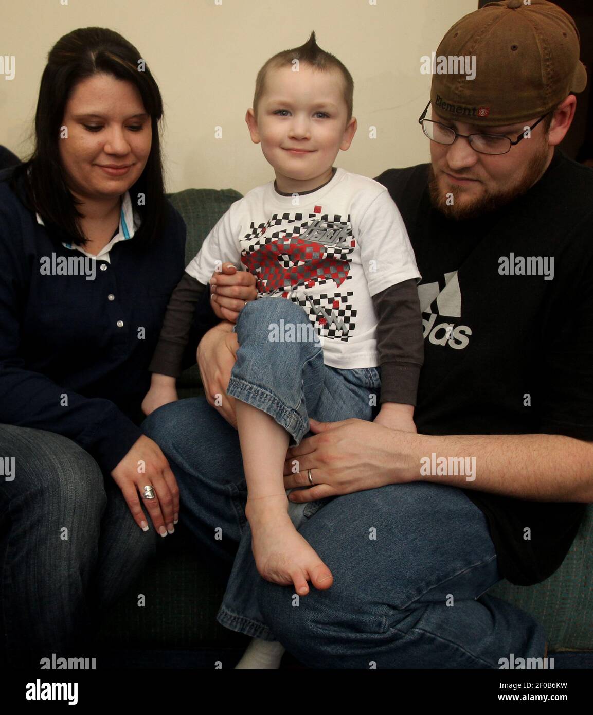 Evan Kerr, 4, sits with his parents Brianne Kerr and Jon Kerr in their ...