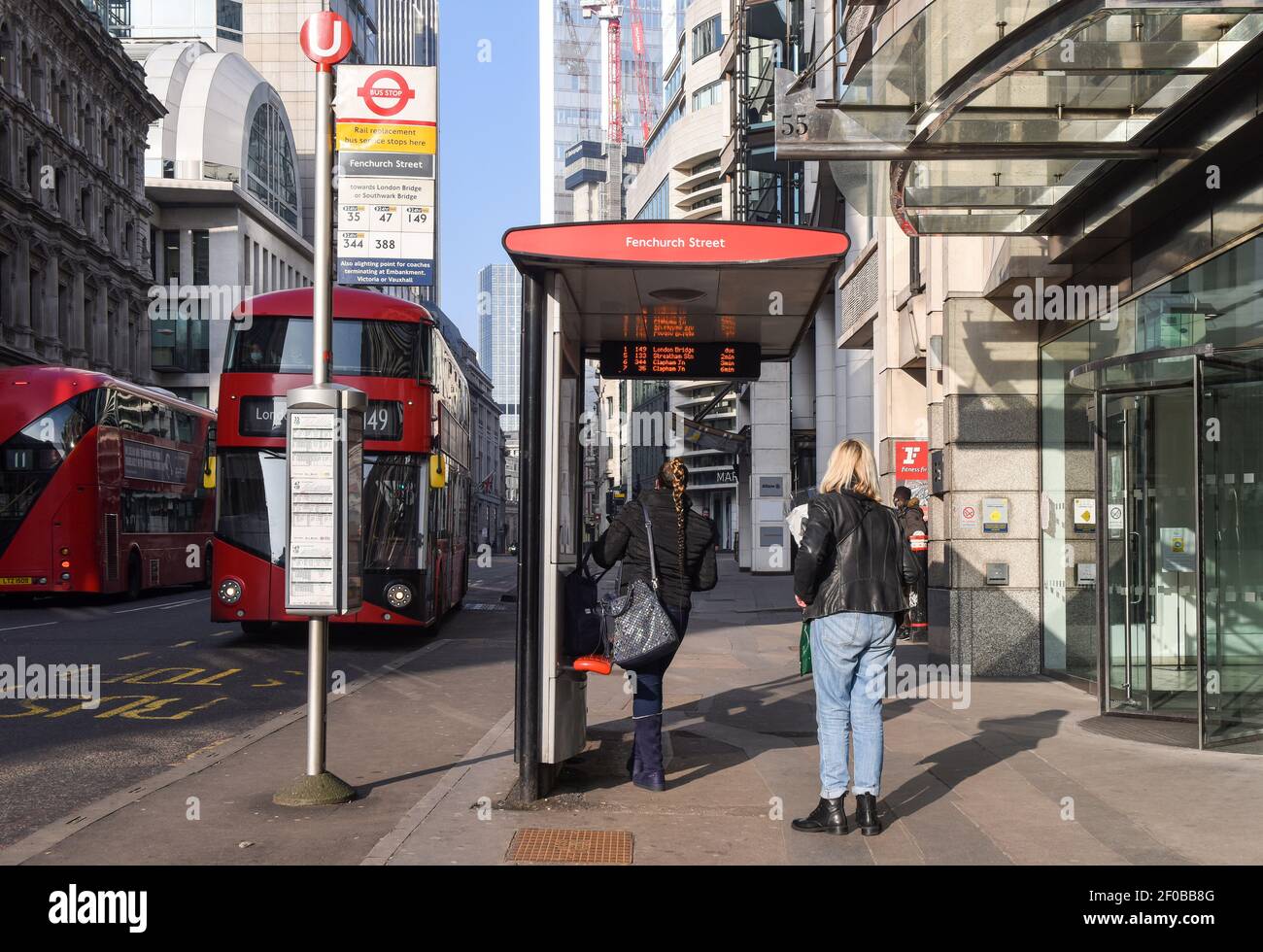 London, UK. 2nd Mar, 2021. People waiting for the bus at the bus stop ...