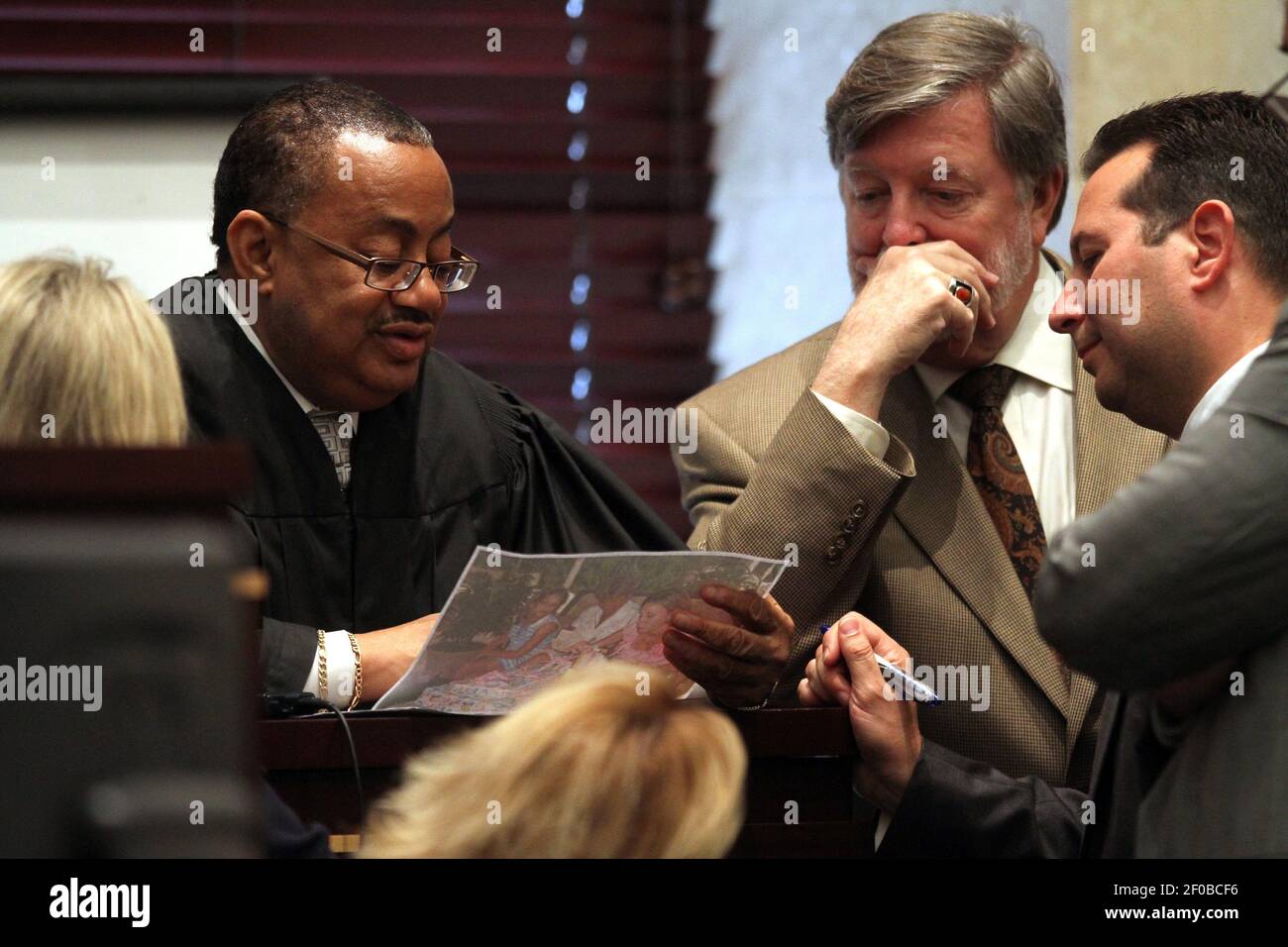 The prosecuting and defense attorneys meet with Judge Belvin Perry in a ...