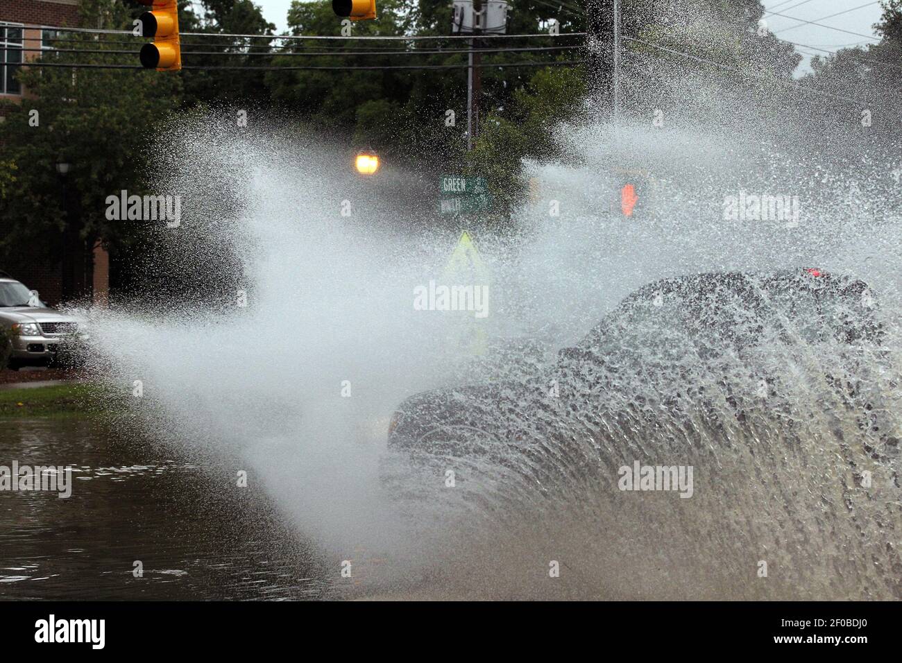 A truck throws up a wall of water almost 20 feet high as it speeds ...