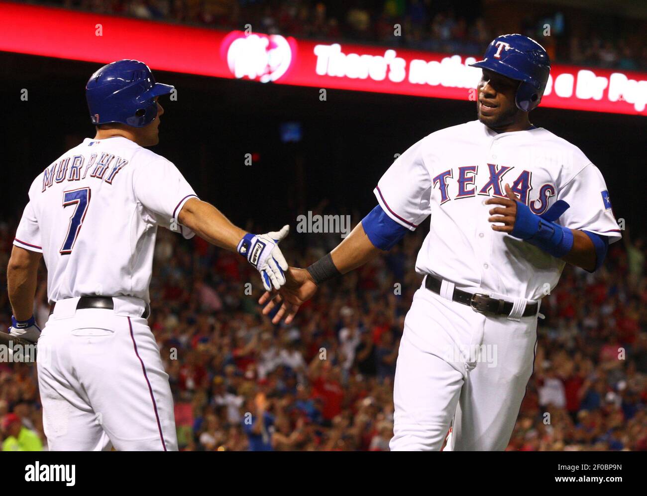 Texas Rangers shortstop Elvis Andrus, right, scores and celebrates with ...
