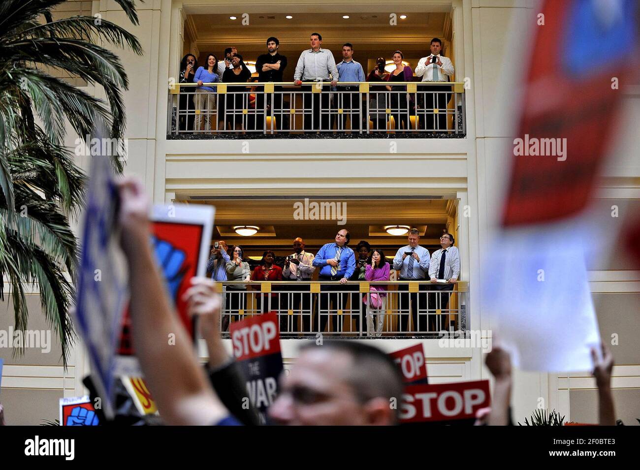 Building workers watch protesters rally inside the lobby of The Homer ...