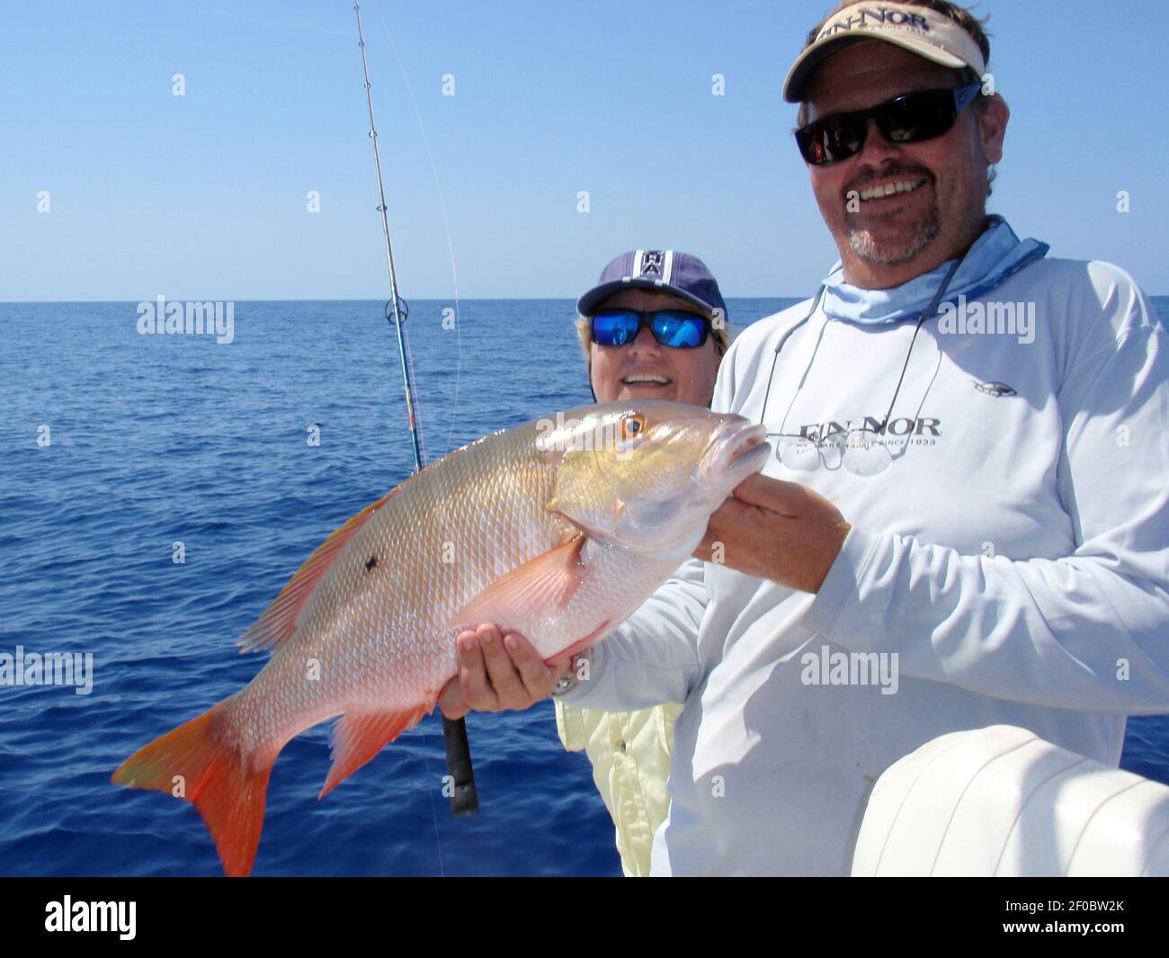 Captain Ted Lund, right, holds up an African pompano caught on a 100 ...