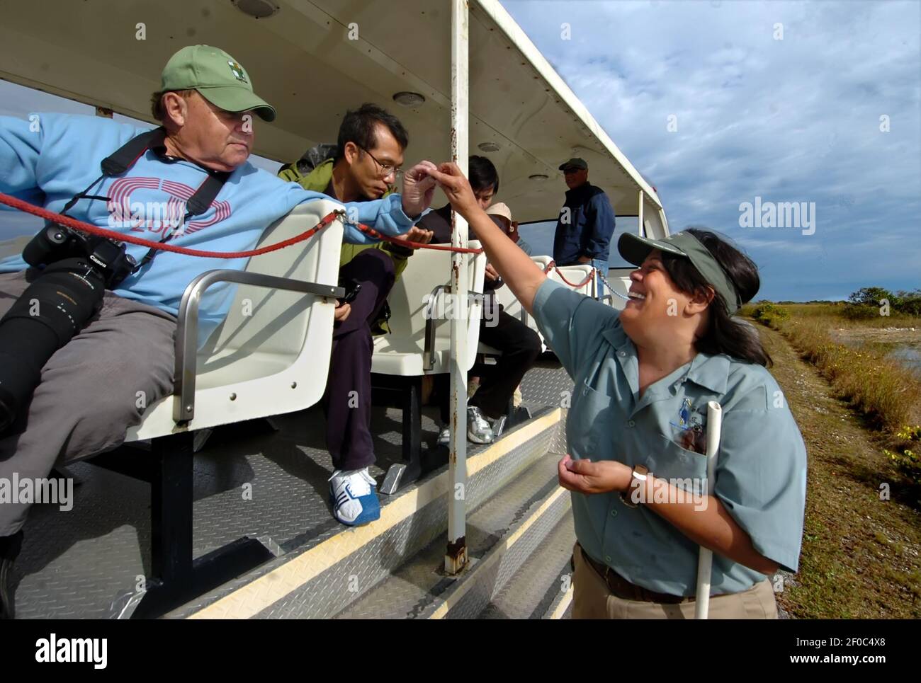 Tram Tour interpreter Eileen Cabral hands visitor Al Weishar a piece of ...
