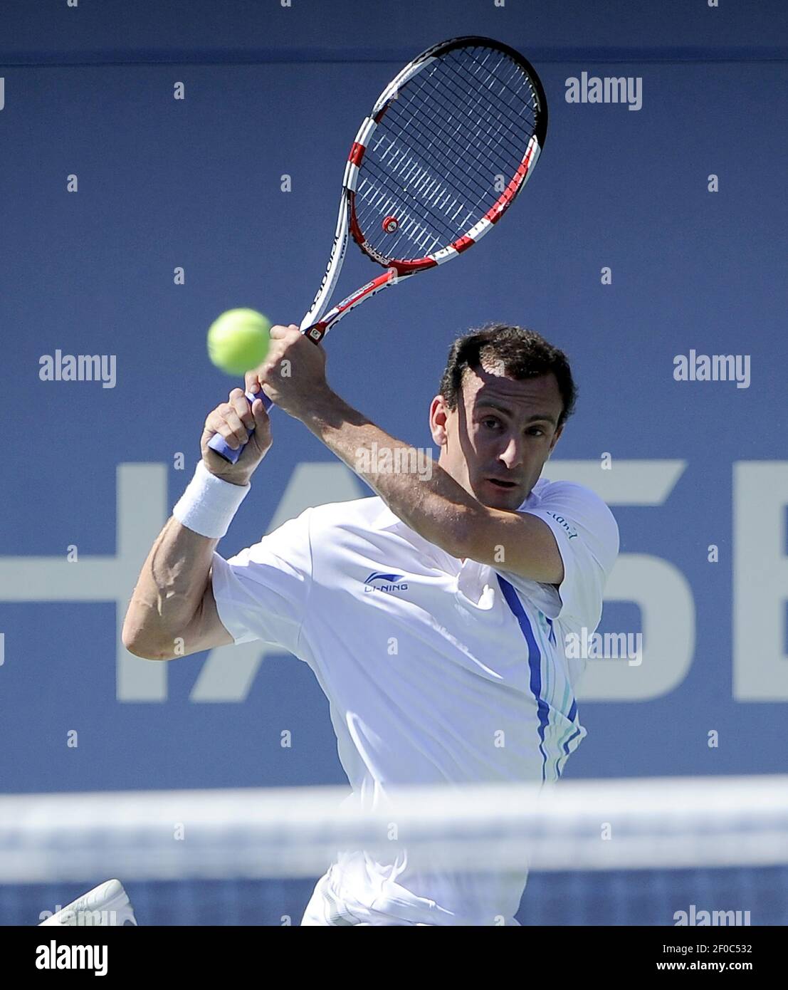 Conor Niland of Ireland returns a ball to Novak Djokovic of Serbia ...
