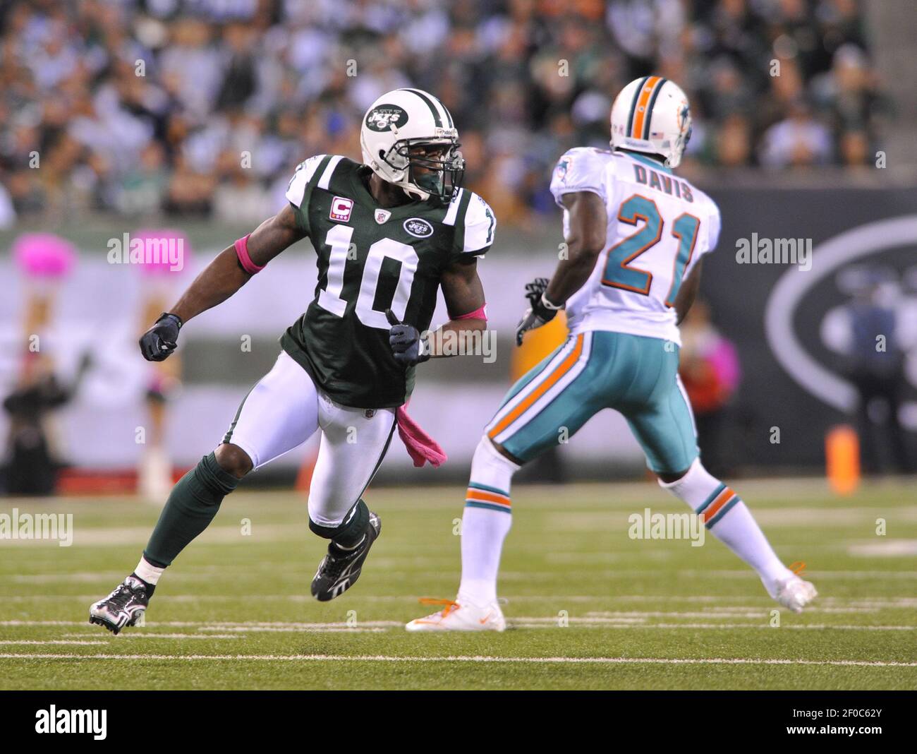 Santonio Holmes of the New York Jets runs a route while being guarded ...