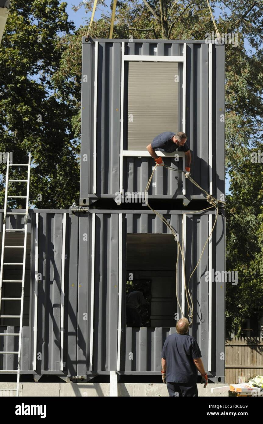 General contractor Che Tiernan, top, helps line up storage containers ...