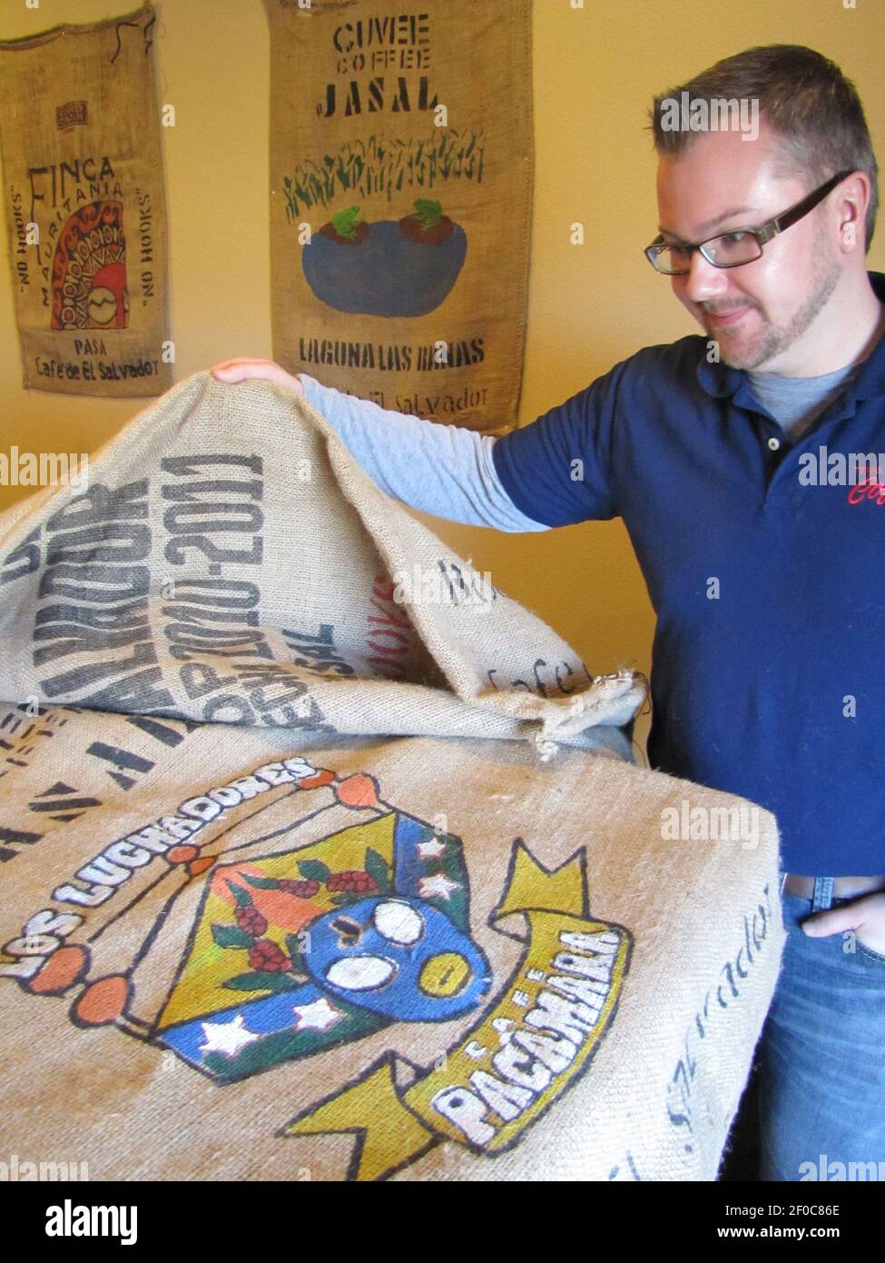 Tom Vincent shows bags of coffee beans from exotic locations at his ...