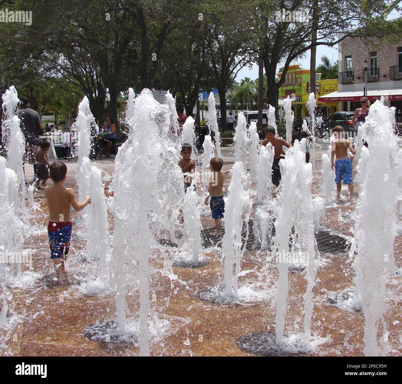 Kids keep cool by splashing in the fountain at the waterfront park in ...