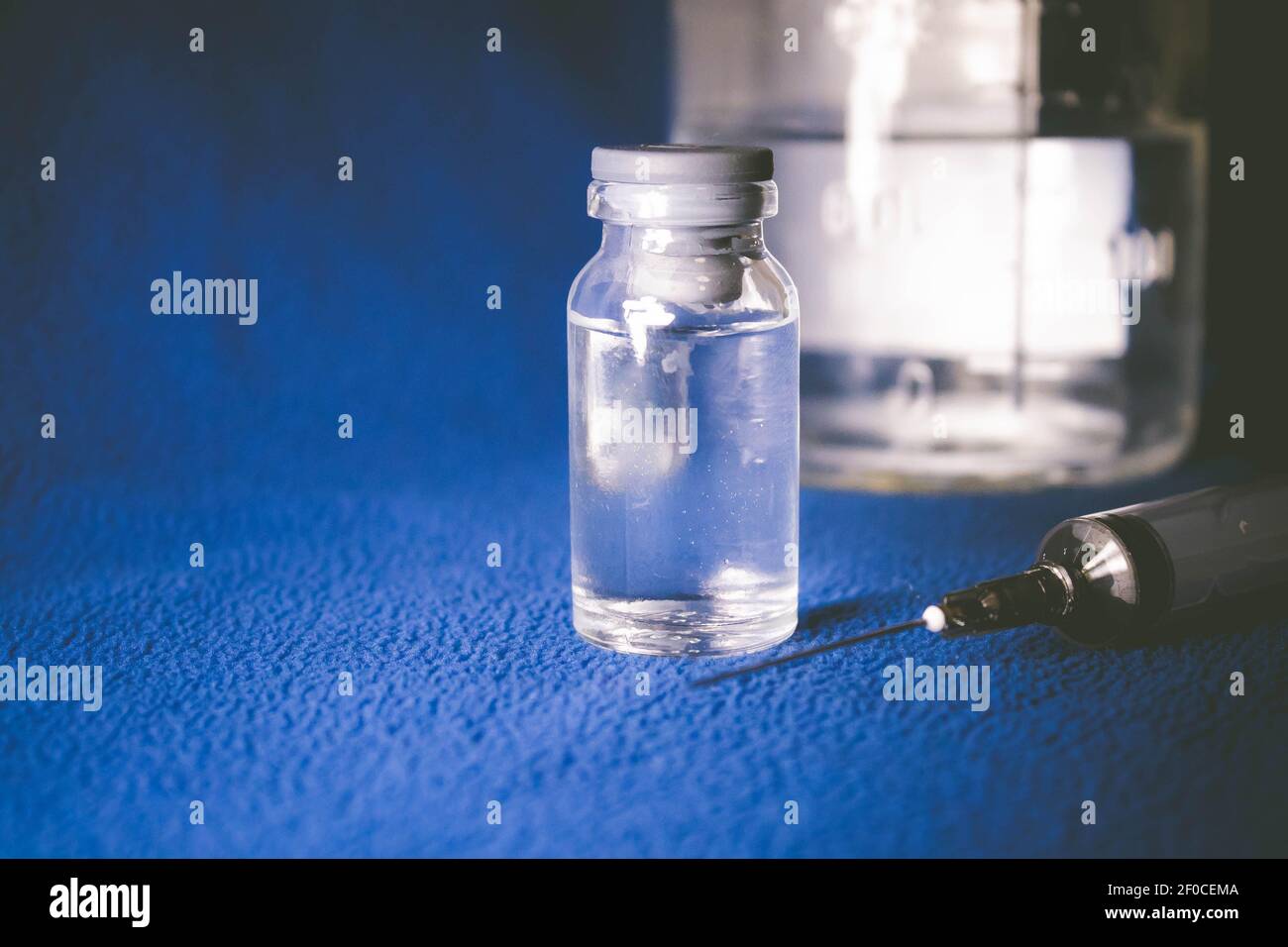 Vaccine in vitro. Medicine in a flask on a blue background. Antibiotic ...