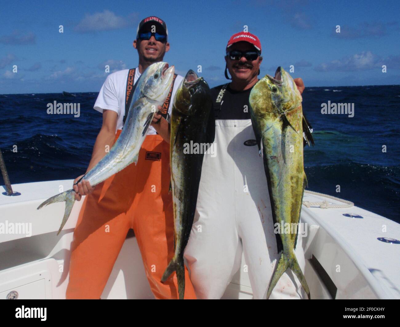 Leo Lombero, left, and captain Dean Panos hold up three dolphins caught ...