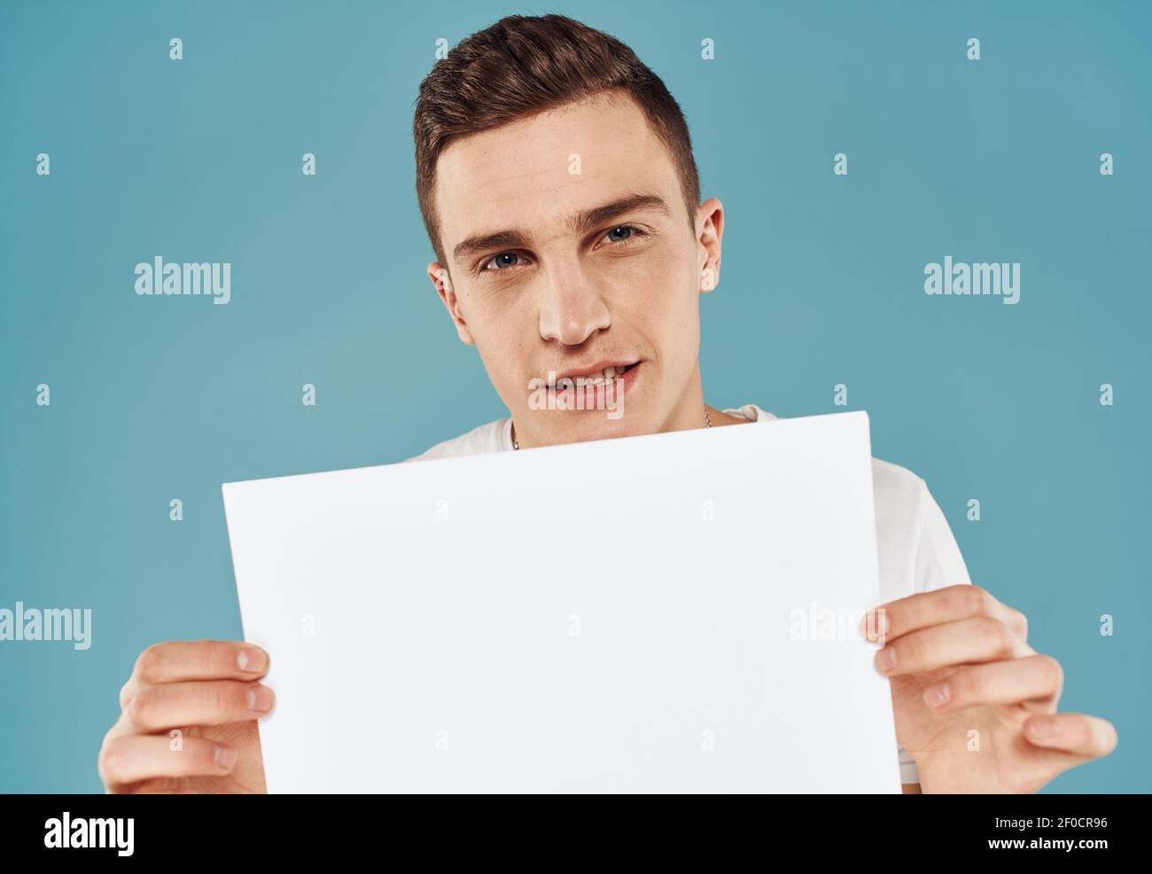 guy with flyer in hand Poster mockup blue background cropped view Stock ...