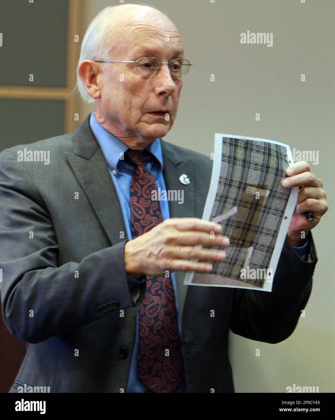 Stuart James, a blood spatter expert, holds a picture Thursday ...