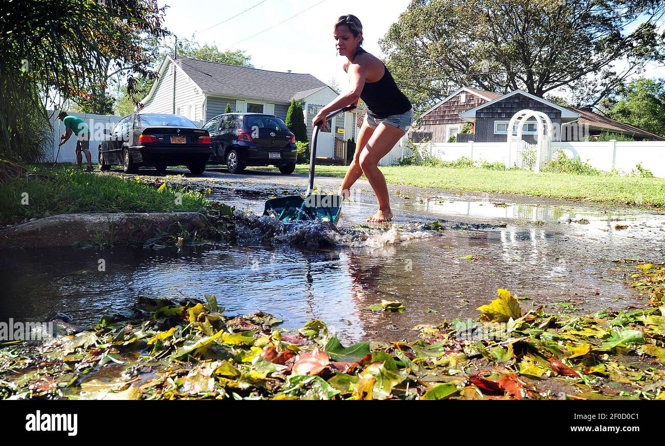 Iliana Chaney, center, and her husband Dan, left, clean up their ...