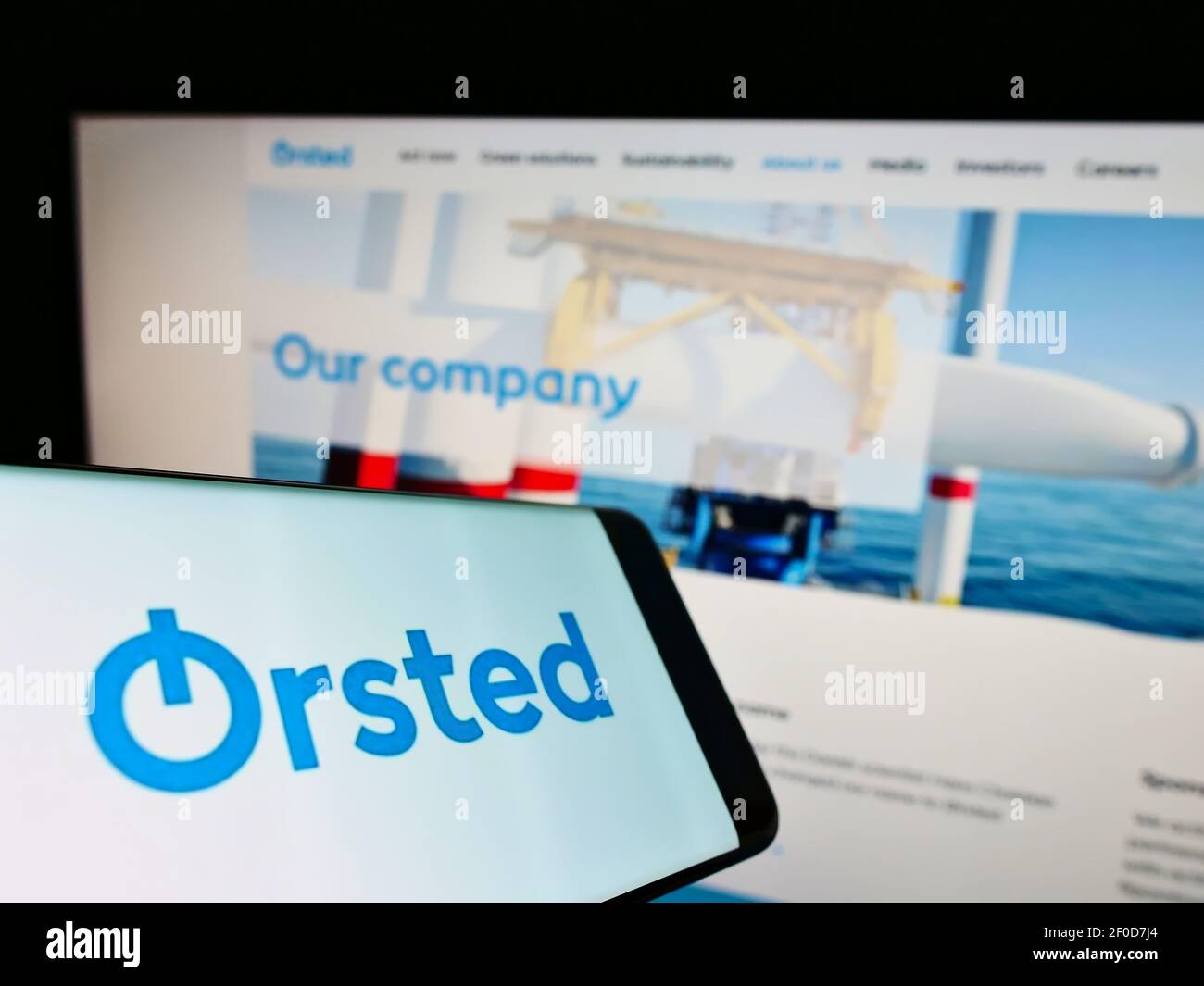 Cellphone with business logo of Danish energy company Ørsted AS on ...