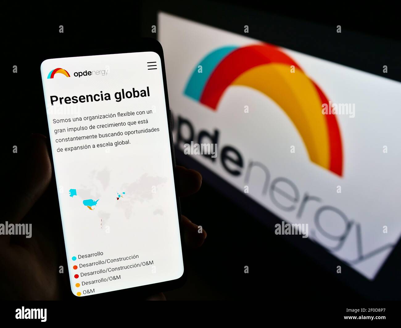 Person holding cellphone with webpage and map of Spanish energy company ...