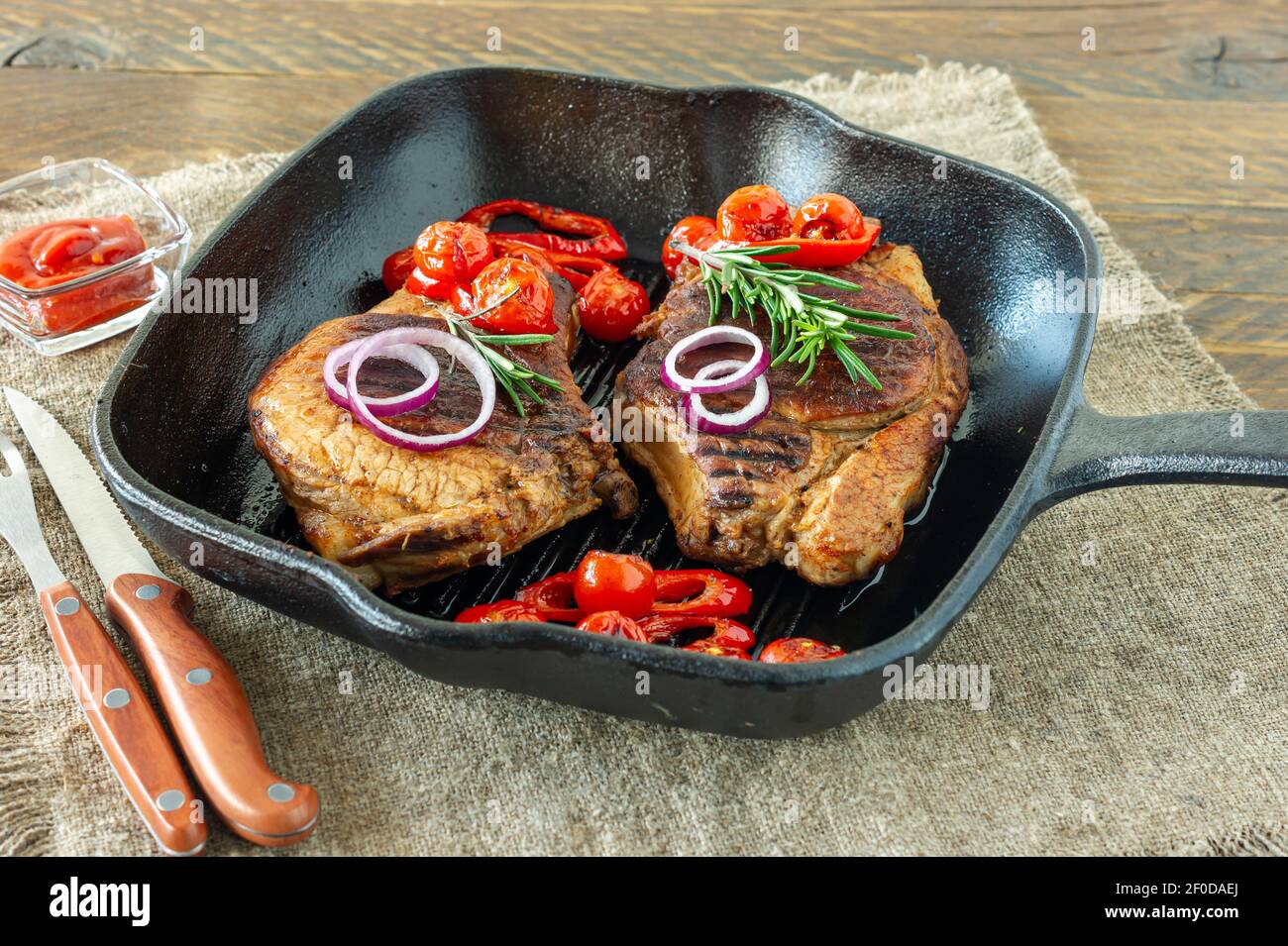 Fresh juicy roasted red meat on grill pen, with spices and vegetables ...