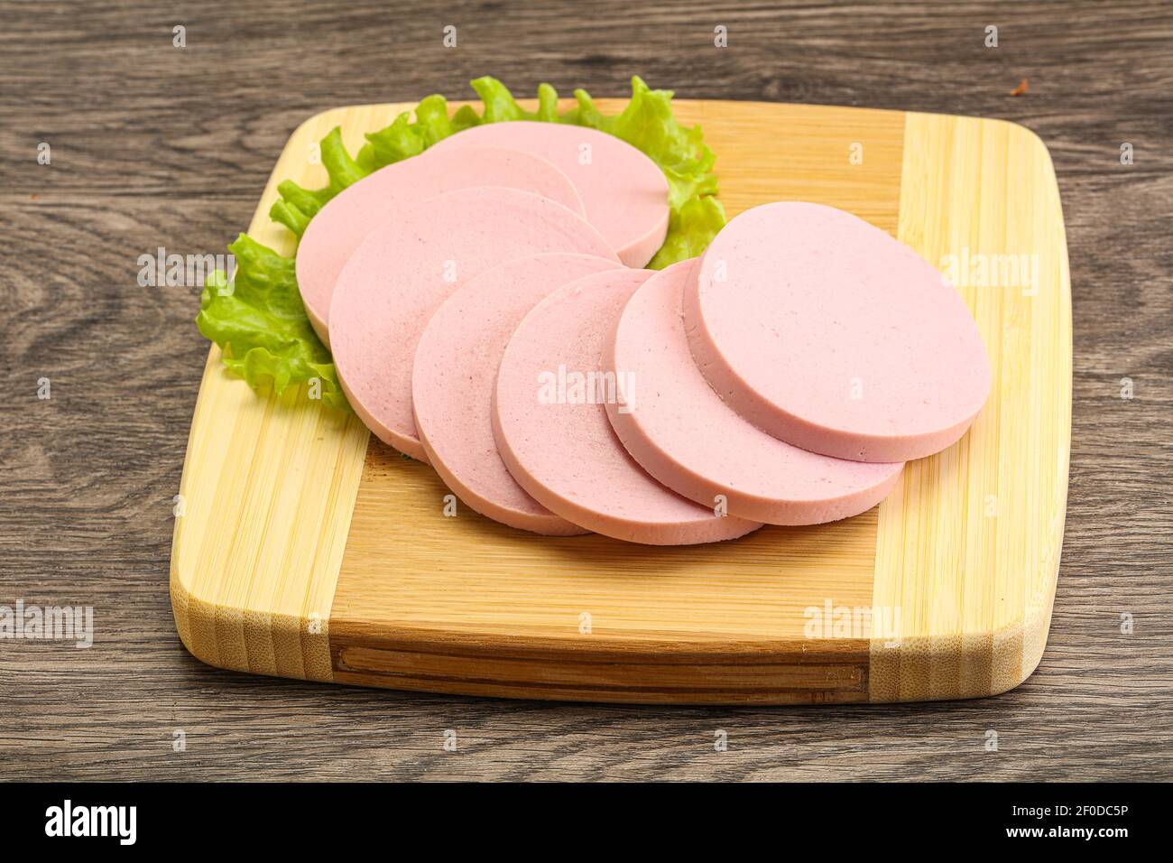 Sliced sausage snak over board served salad leaves Stock Photo - Alamy