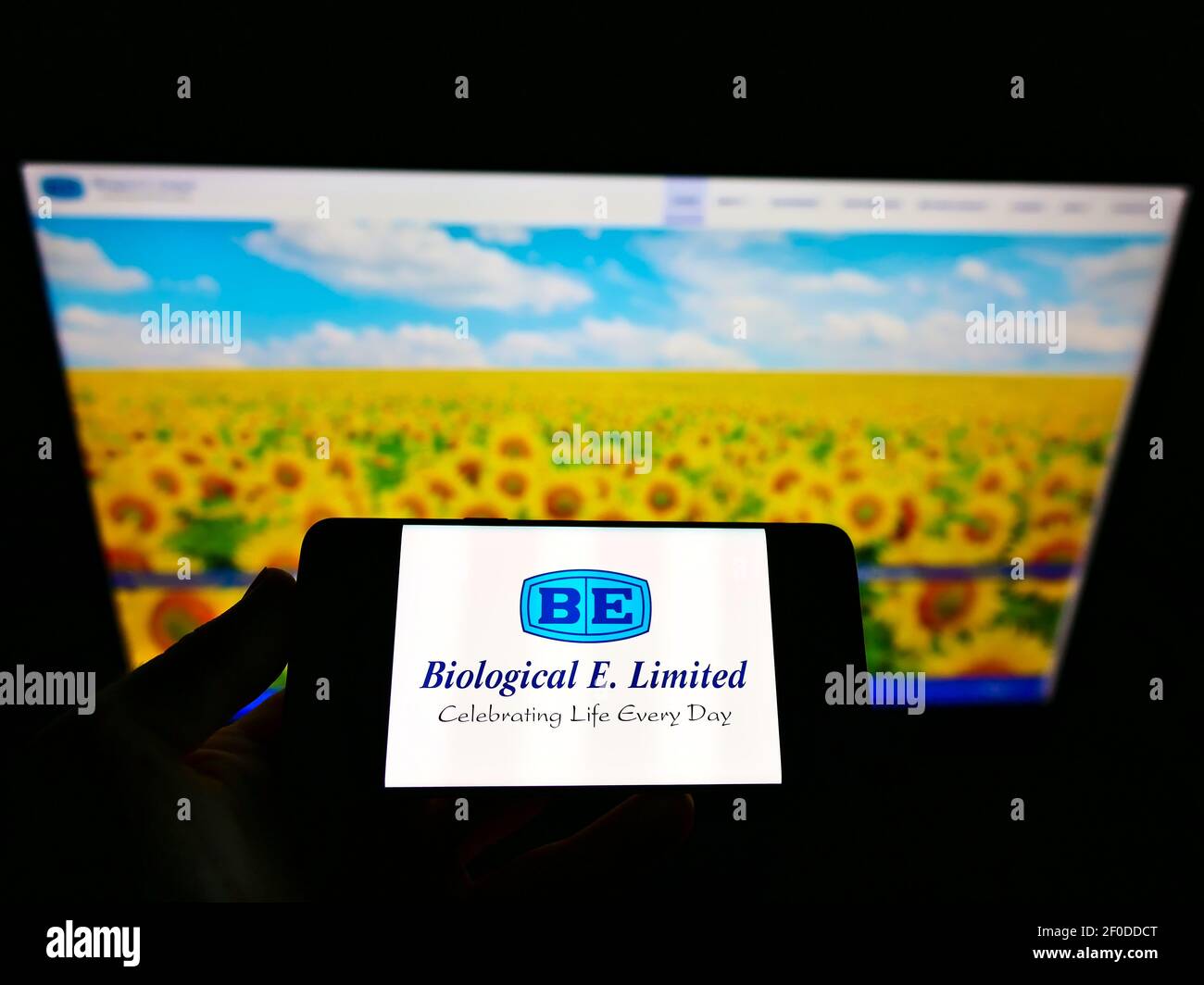 Person holding mobile phonewith logo of Indian biopharmaceutical ...