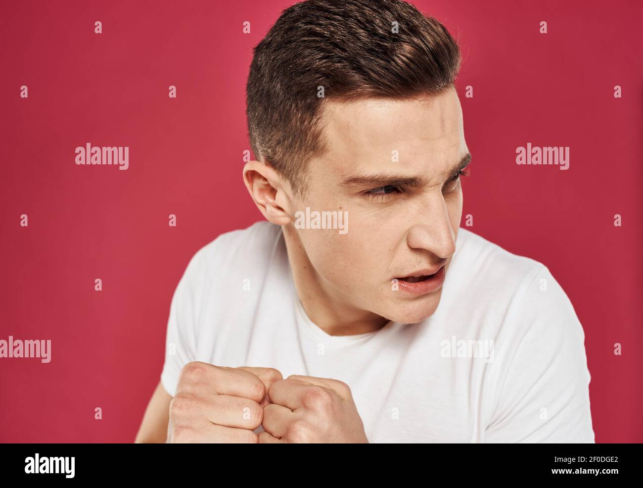 angry man displeased facial expression close up emotion red background ...