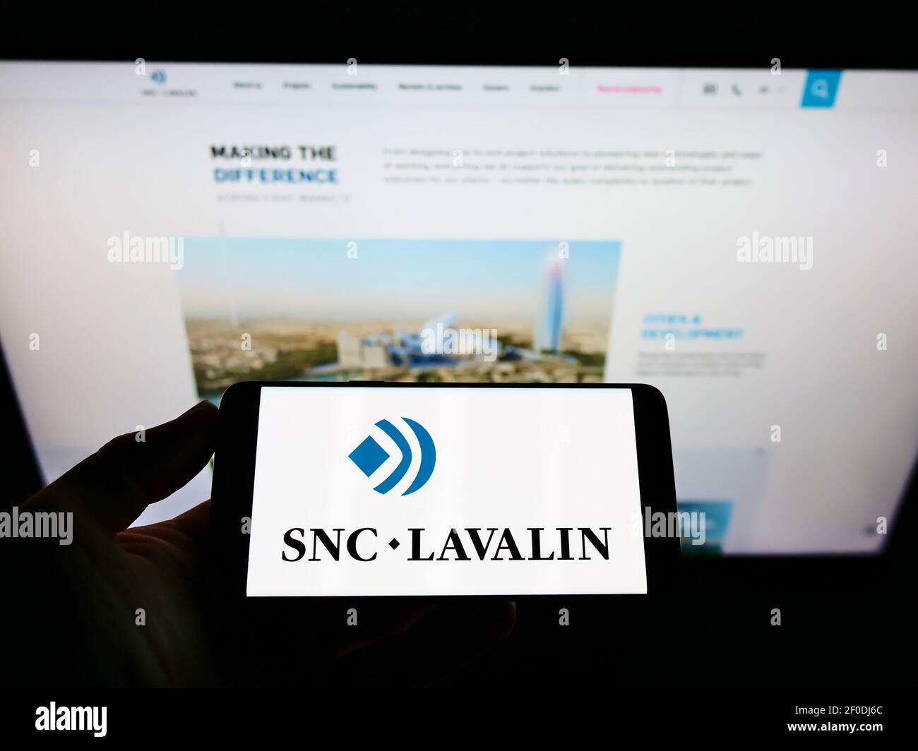 Person holding mobile phone with business logo of Canadian company SNC-Lavalin Group Inc. on ...