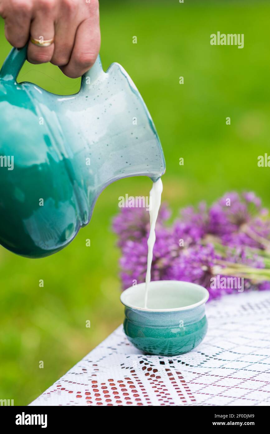Milk being poured into cup Stock Photo - Alamy