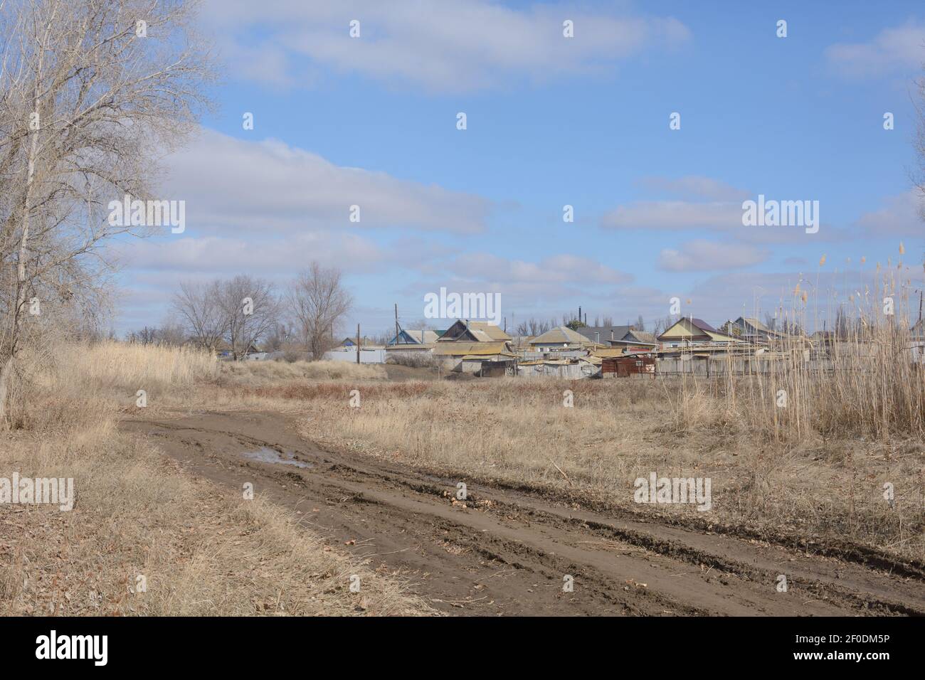Outskirts of village in early spring. Dirty road, beautiful sky and ...