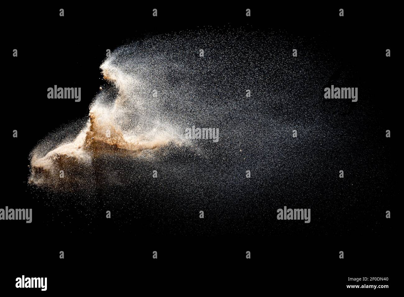 Sand flying explosion isolated on black background. Freeze motion of ...