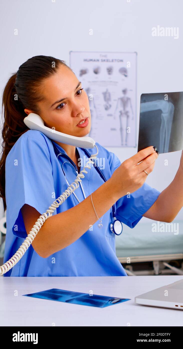 Nurse answering at hospital call checking the result of patient x-ray ...