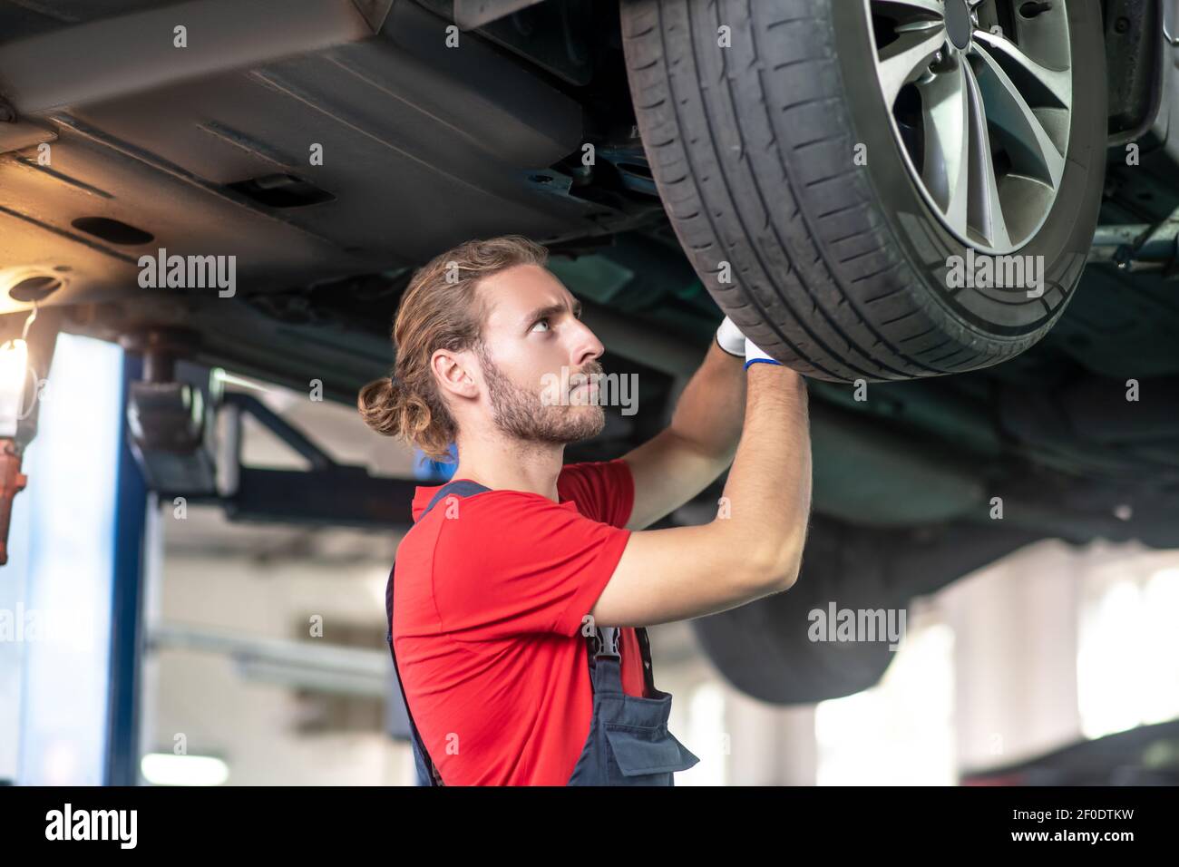 Concerned man in uniform repairing a car Stock Photo - Alamy
