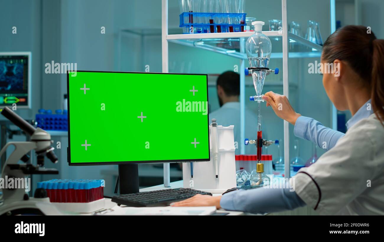 Microbiology scientist typing on keyboard works with green chroma key ...