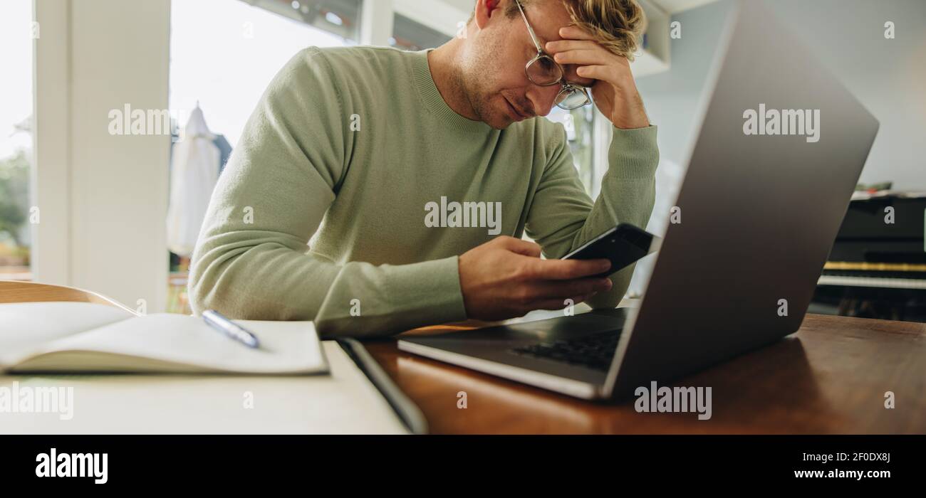 Man looking stressed while working from home. Tired looking man sitting ...