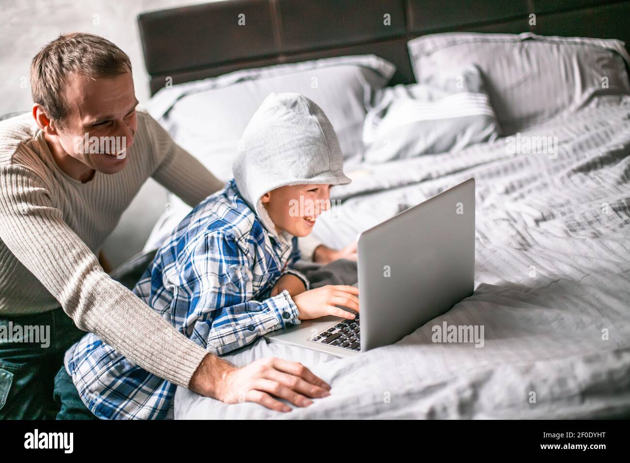 Father and boy play computer games at home together. son chooses a gift ...