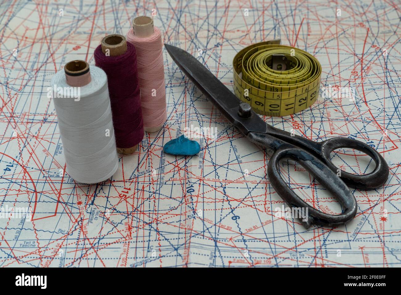 Sewing threads, scissors, chalk and a meter to measure the material on ...