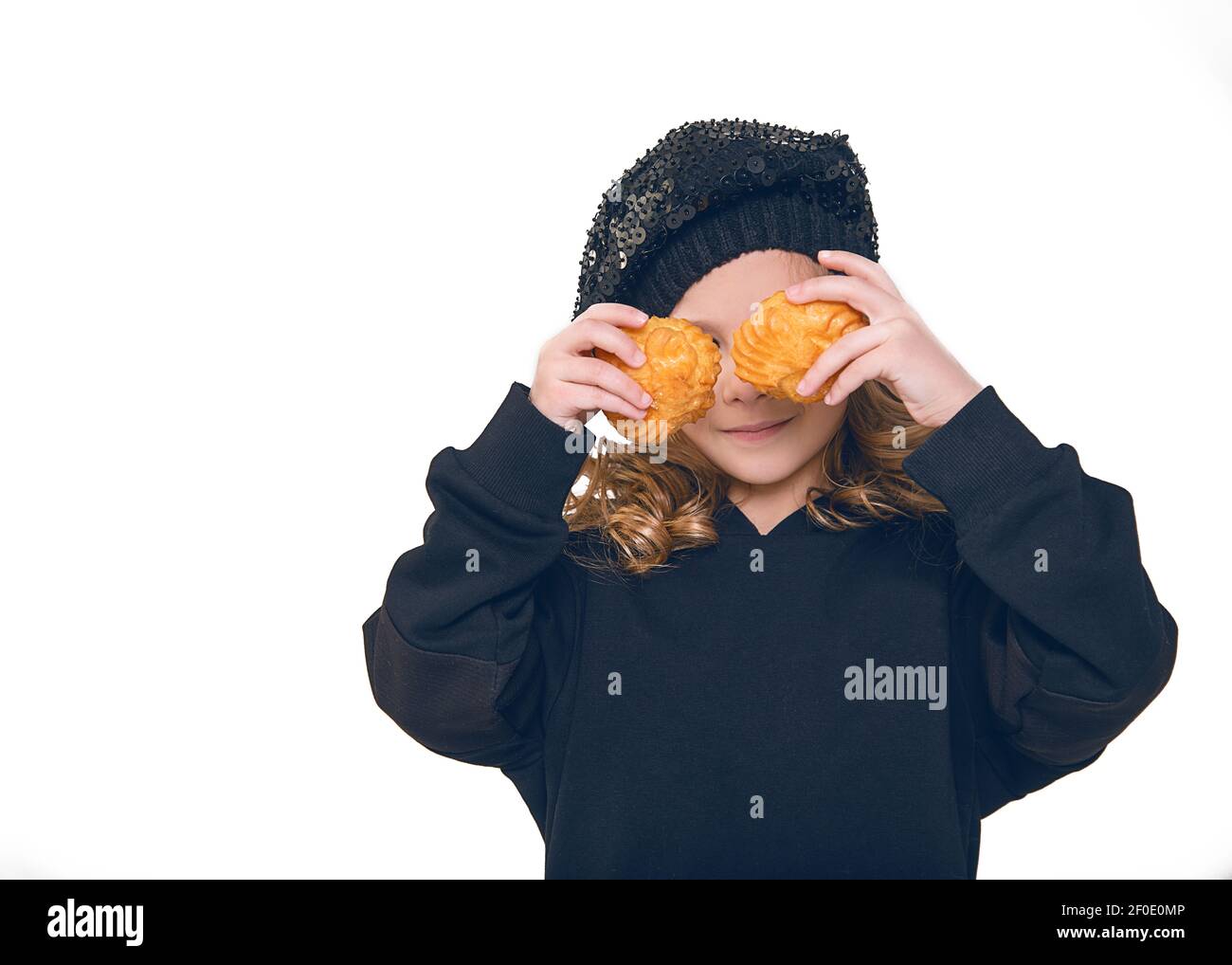 Little girl posing on white background in studio with two cookies in ...
