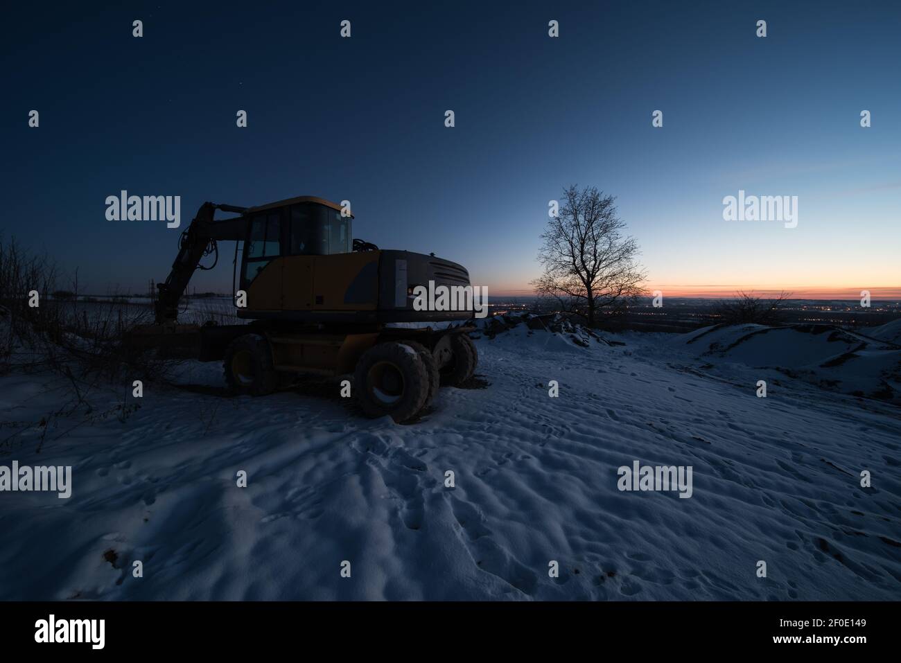 an excavator in the blue hour, the picture was taken in winter in ...