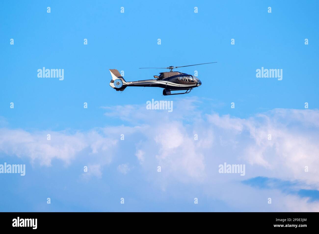 Beautiful view of a helicopter flying over the clouds with a blue sky ...