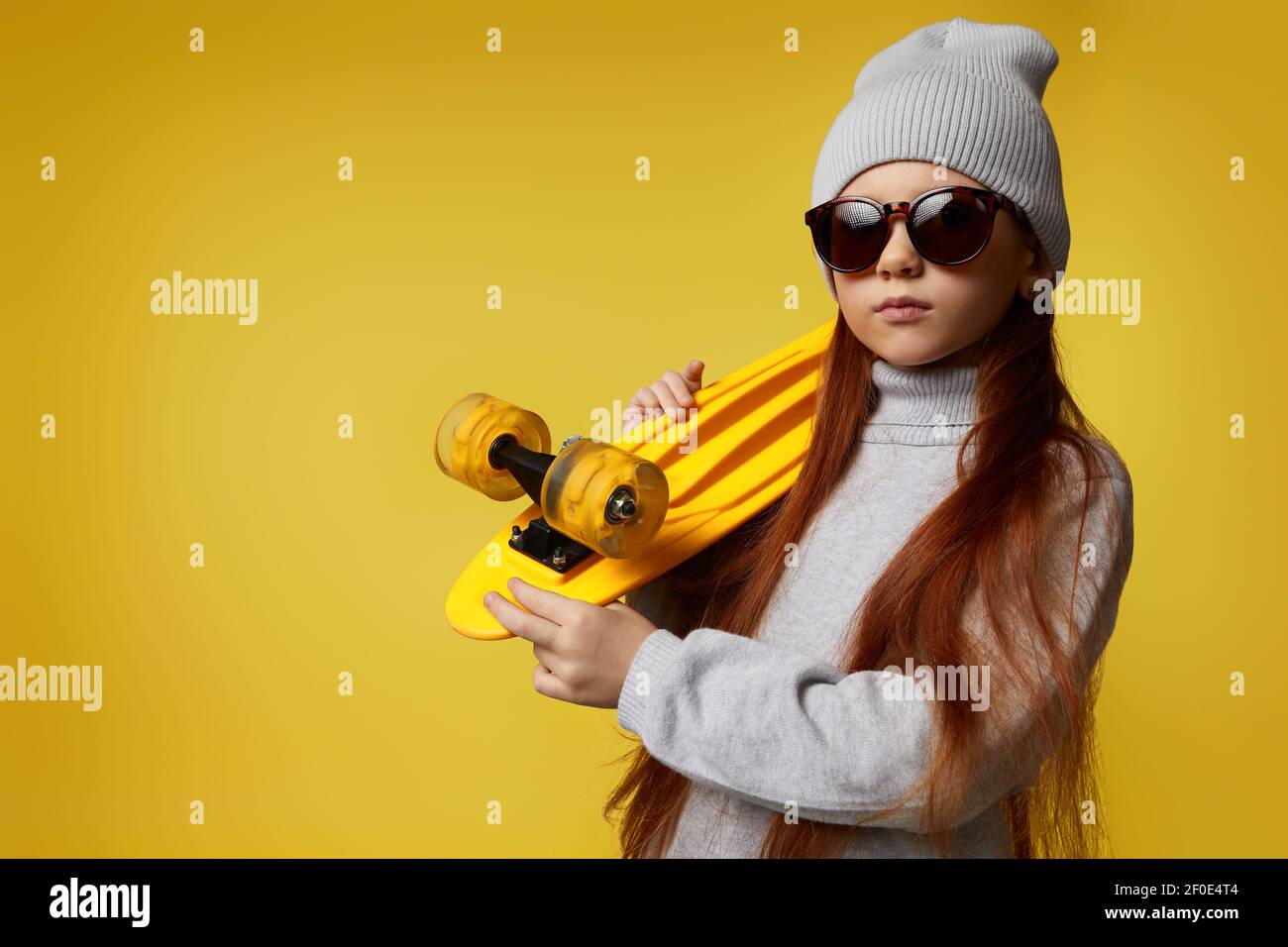 cool little child girl in hat and sunglasses posing with yellow ...