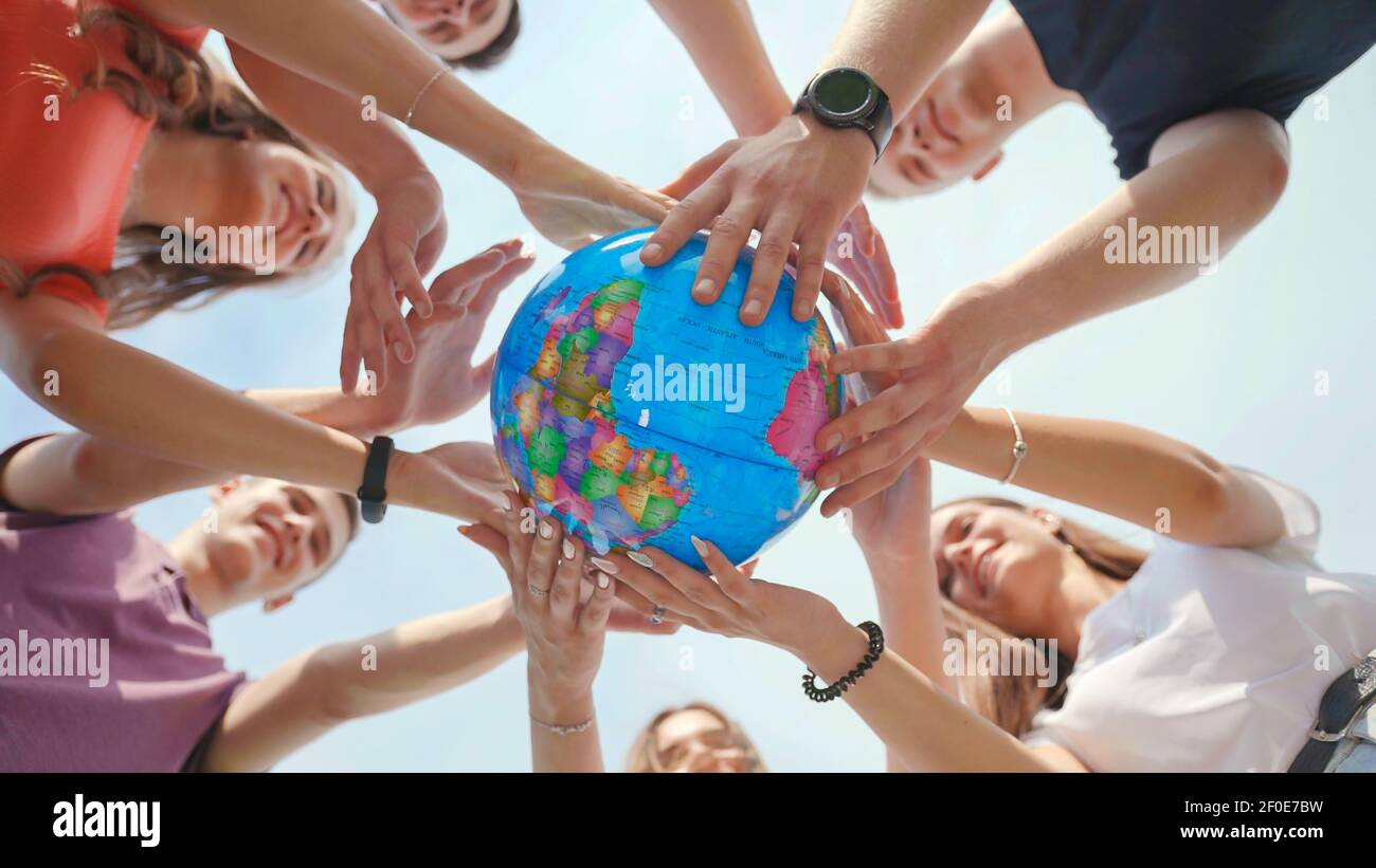 The concept of saving the world. A group of friends hold the world ...