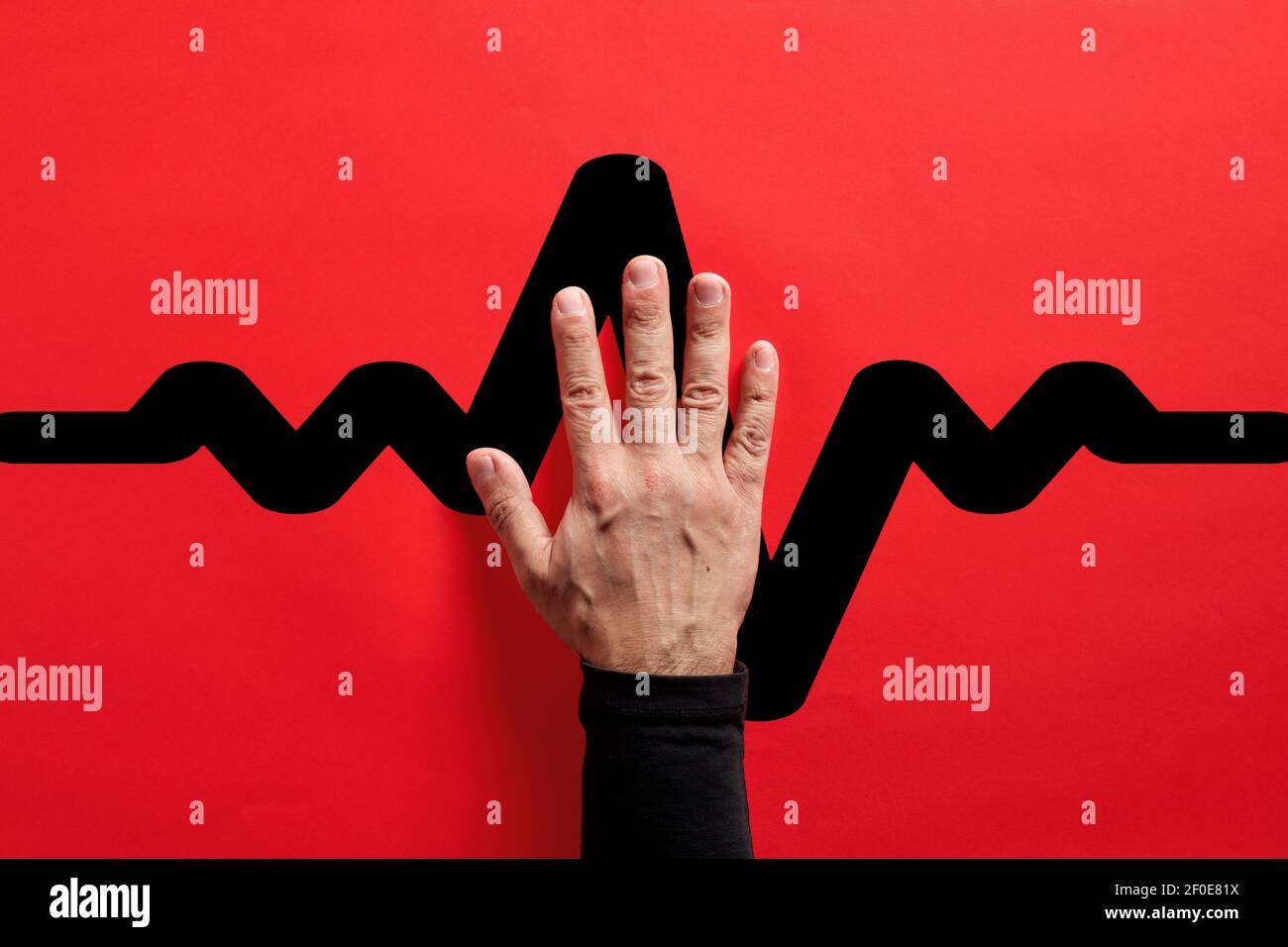 Male hand checking heartbeat rate by pressing on pulse or ecg line on red background. Heart ...